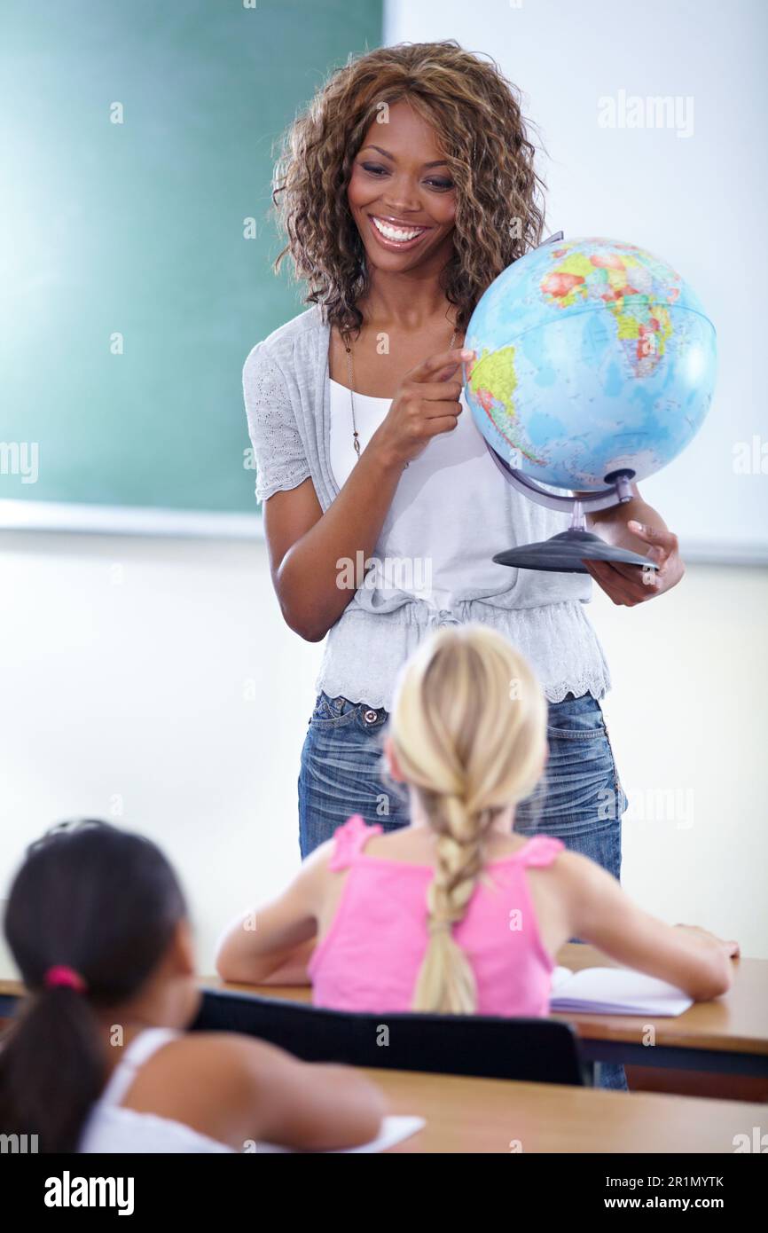 Geography, globe and teacher with children in classroom for education, world learning and happy ...