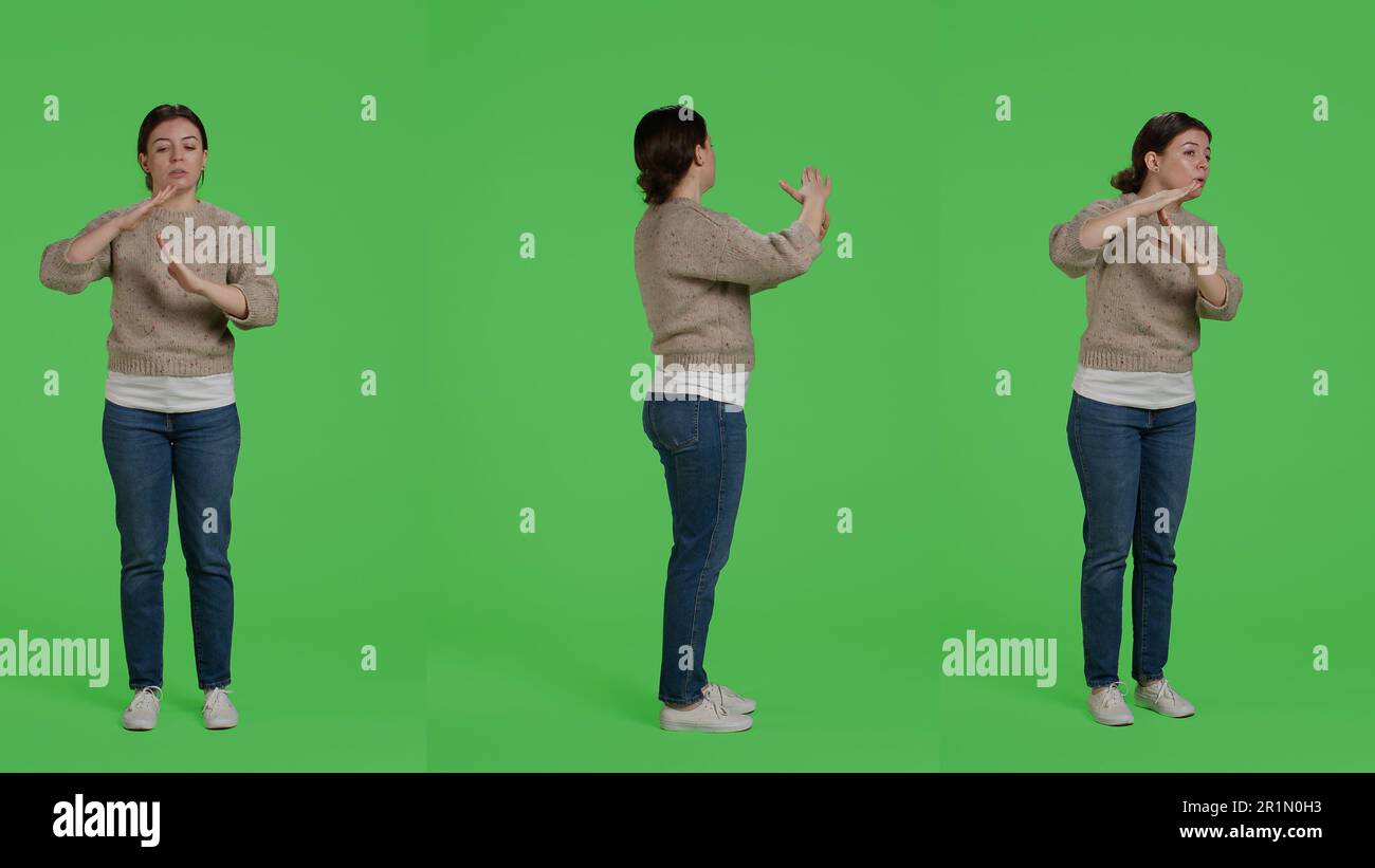Full body of model doing t shape timout sign on green screen backdrop ...