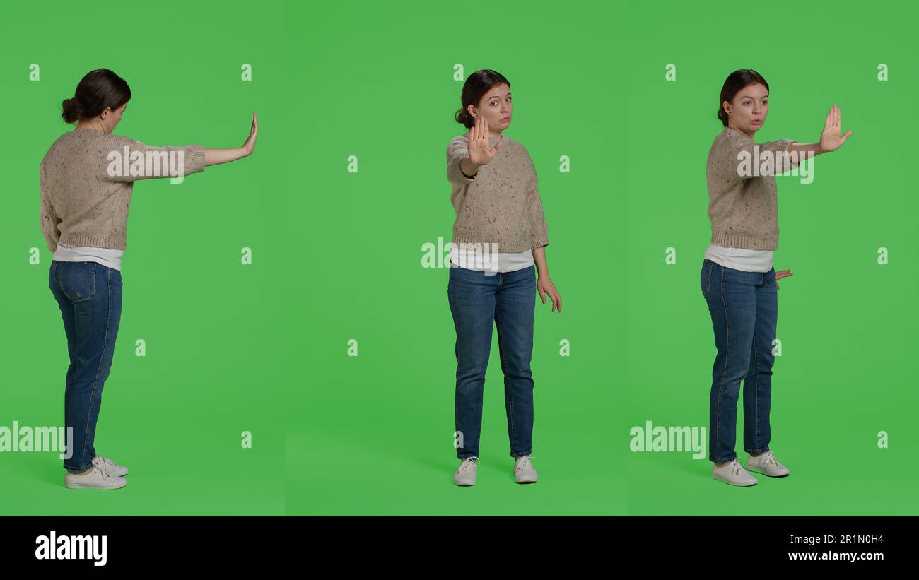 Female model showing palm over greenscreen background Stock Photo - Alamy