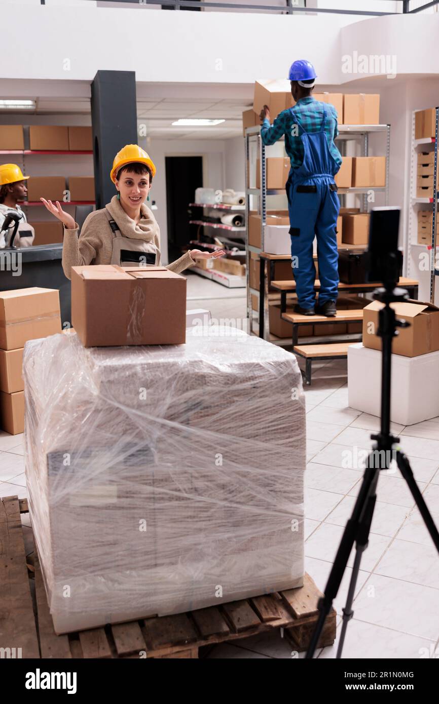 Storehouse worker recording package packing educational tutorial in ...