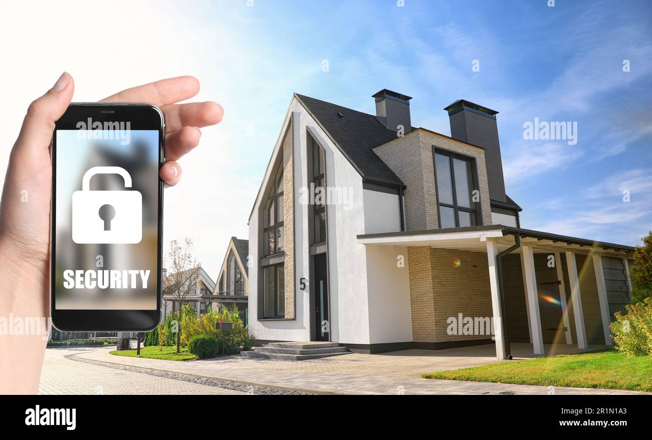 Home security system. Woman with smartphone near her house outdoors ...