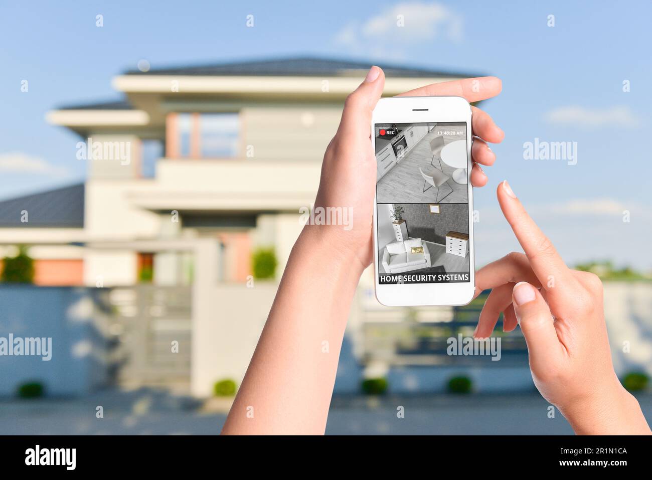 Home security system. Woman monitoring CCTV cameras on smartphone near ...