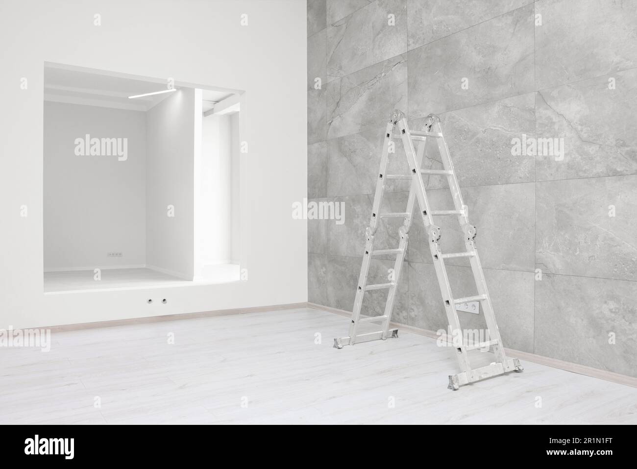 Empty room with tiled wall, ladder and opening for fake window during ...