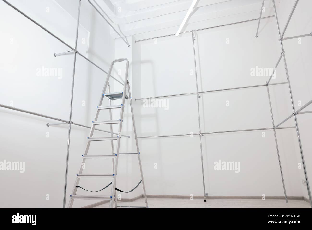 Ladder and metal pipes in empty renovated room Stock Photo - Alamy