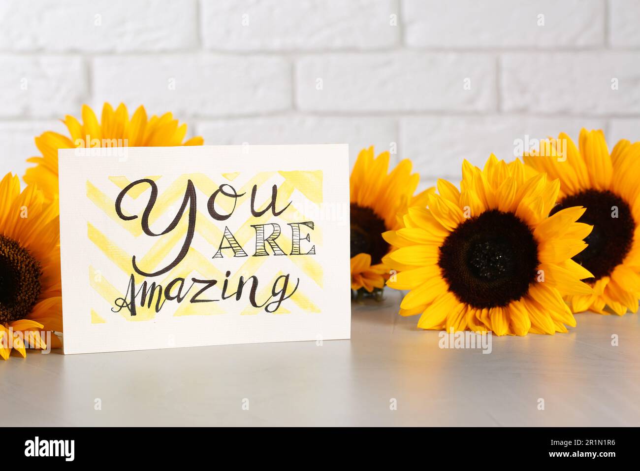 Card with life-affirming phrase You Are Amazing and sunflowers on light ...