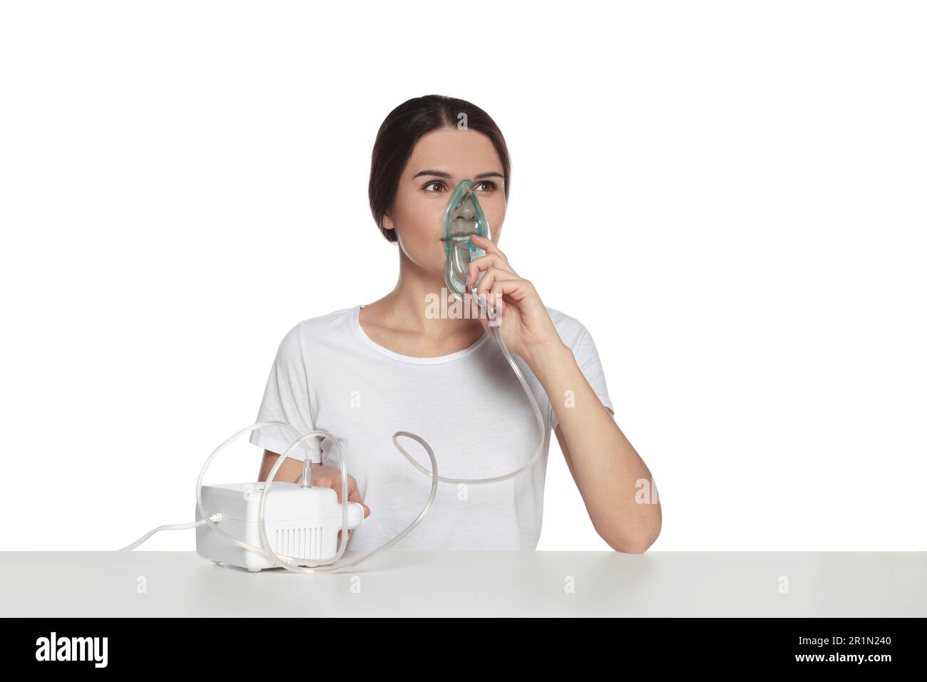 Young woman using nebulizer at table on white background Stock Photo ...