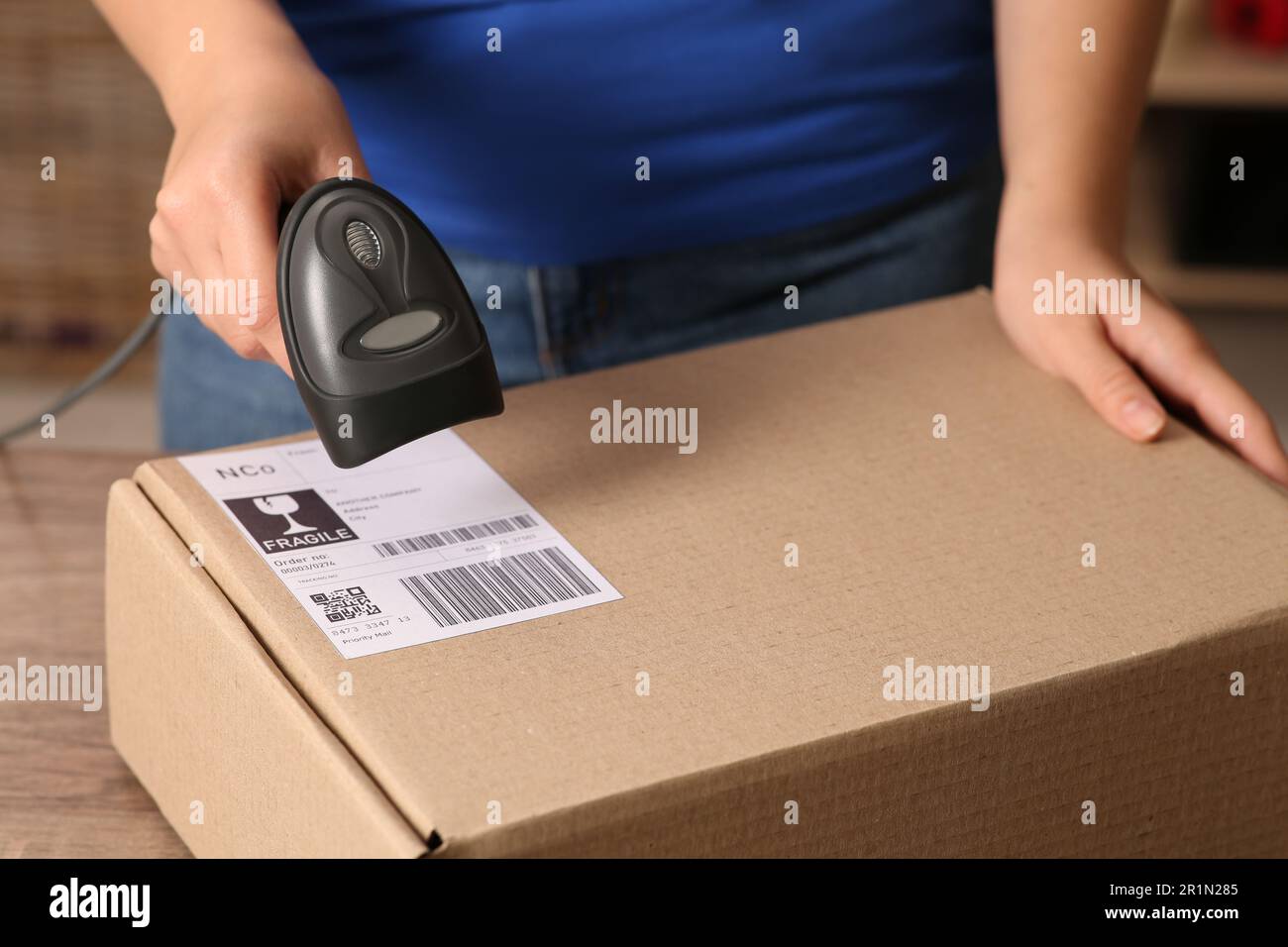 Post office worker with scanner reading parcel barcode at counter ...