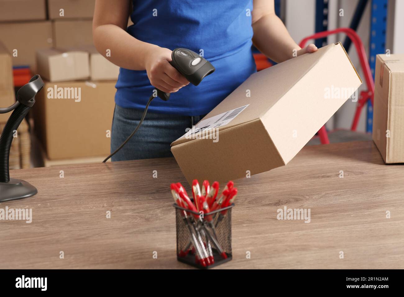 Post office worker with scanner reading parcel barcode at counter ...