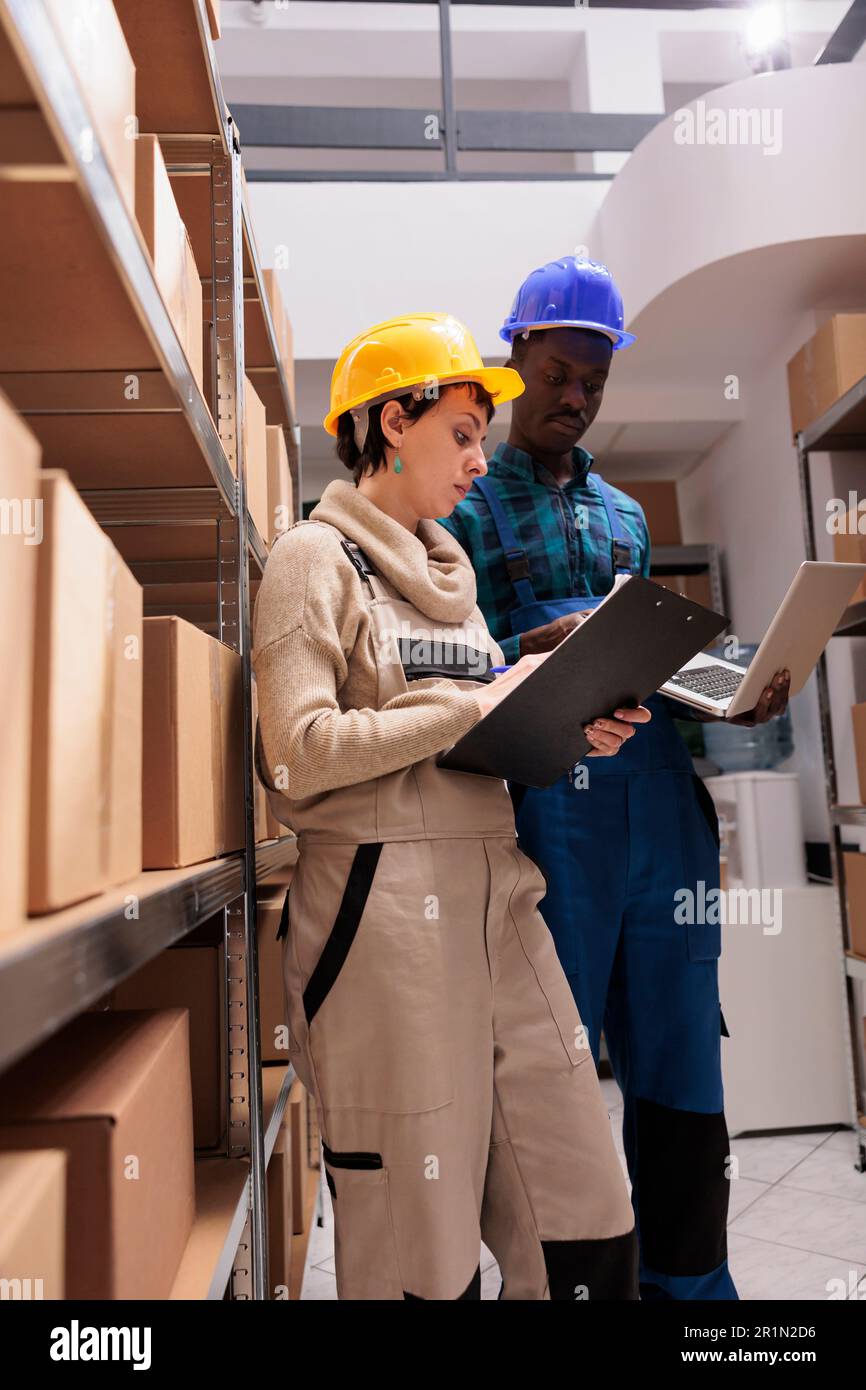 Warehouse assistants reading inventory report and comparing data Stock Photo - Alamy