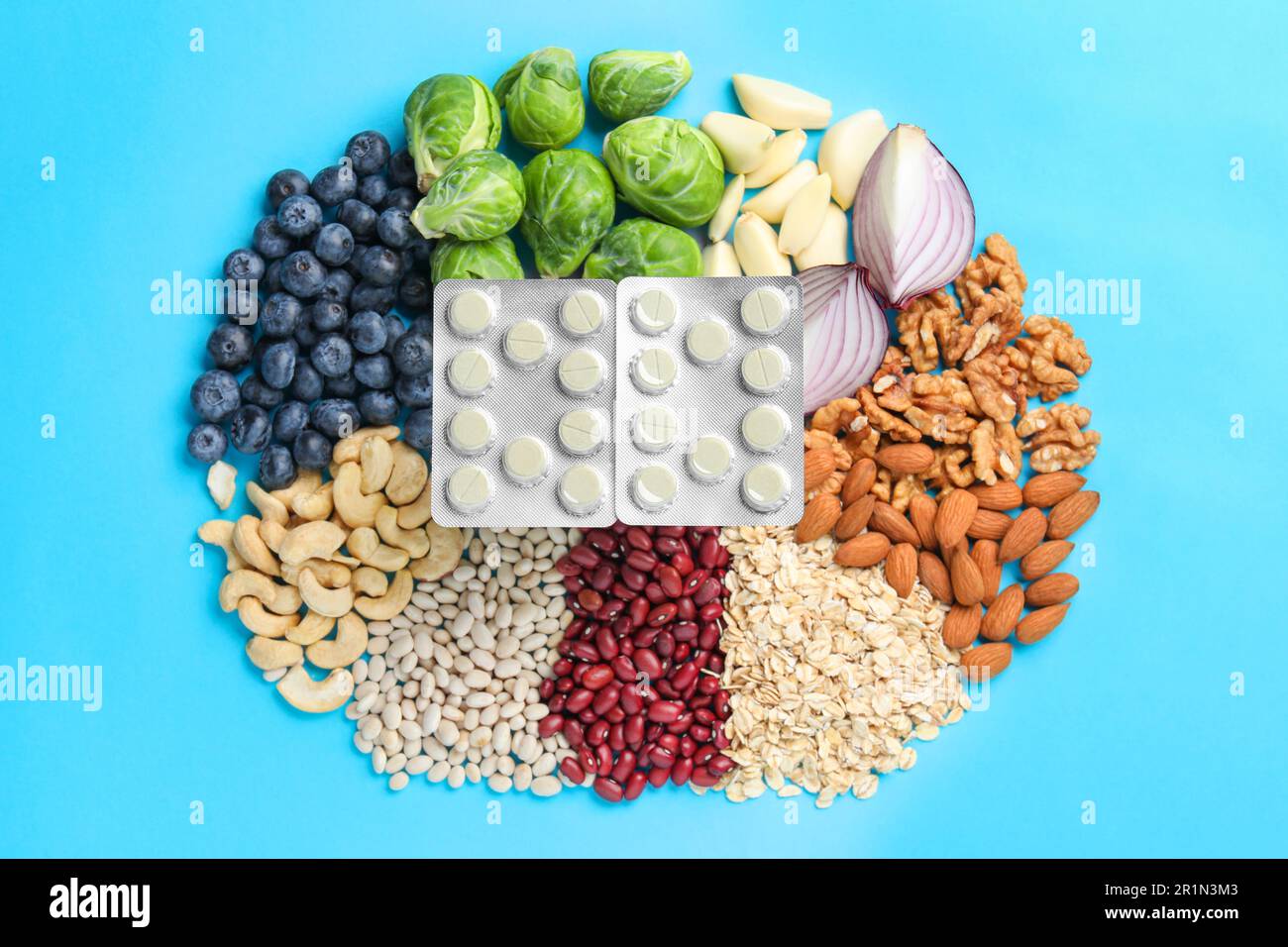 Blisters of pills and foodstuff on light blue background, flat lay ...