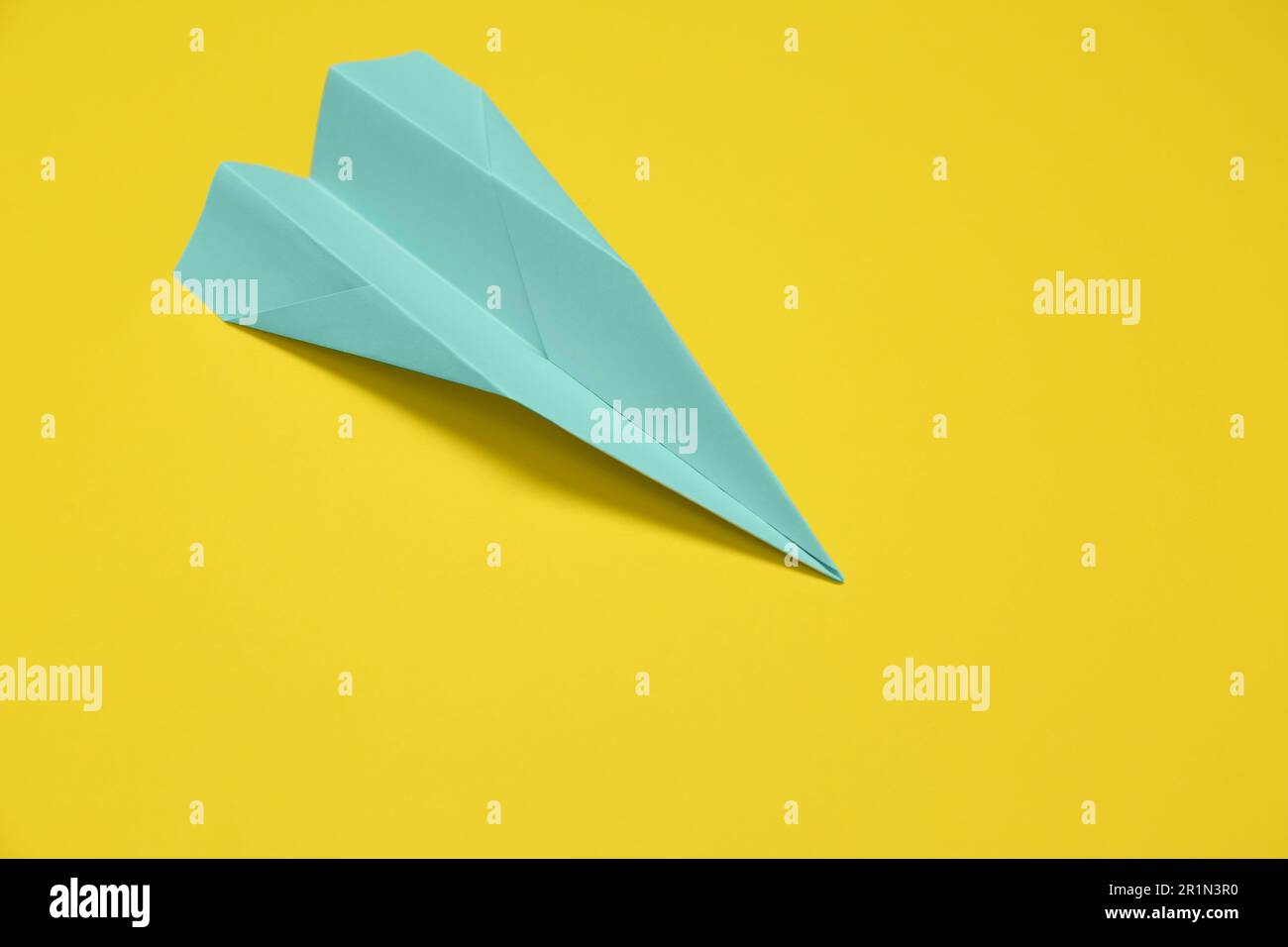 Light blue paper plane on yellow background, space for text Stock Photo ...
