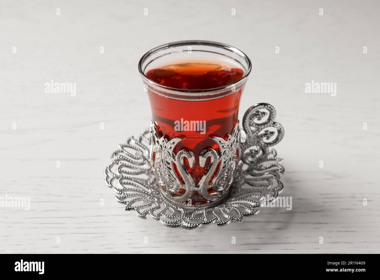 Glass of traditional Turkish tea in vintage holder on white wooden ...