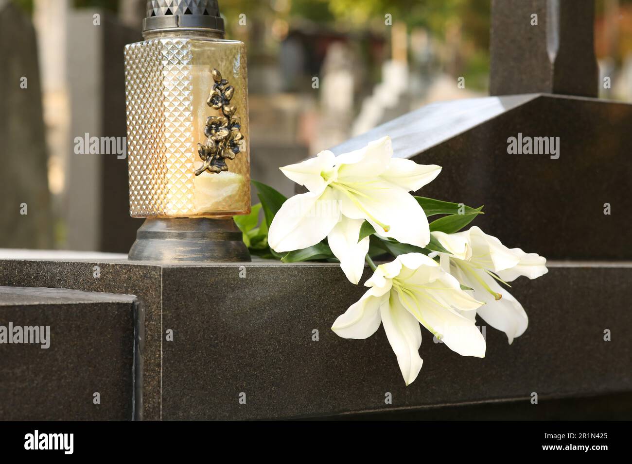 White lilies and grave light on grey granite tombstone outdoors. Funeral ceremony Stock Photo ...