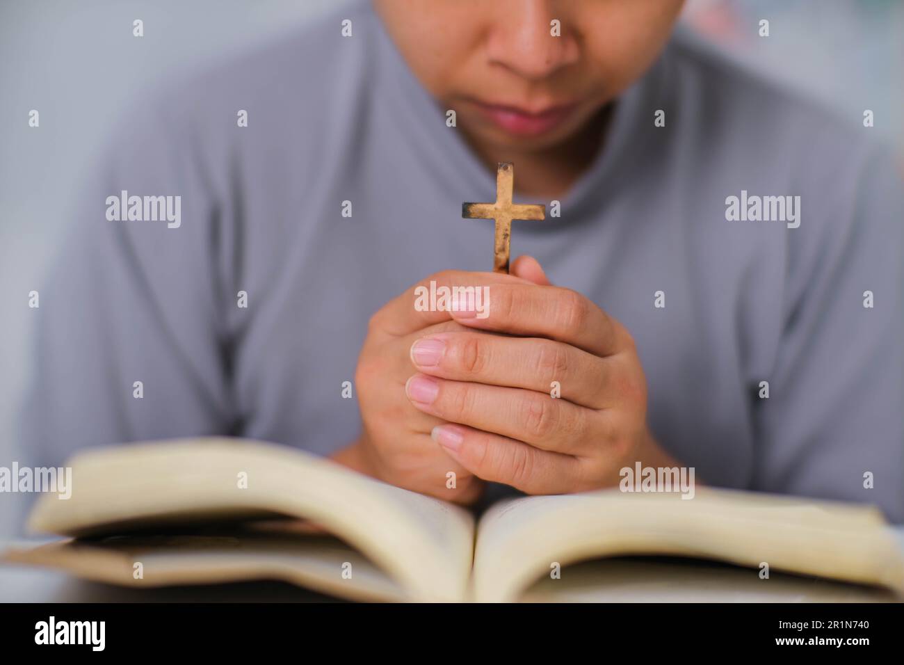 Close-up of a woman reading an open bible, praying and holding hands on ...