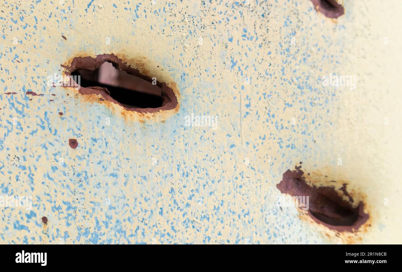 Bullet hole in metal. War in Ukraine. A hole from a shell fragment ...