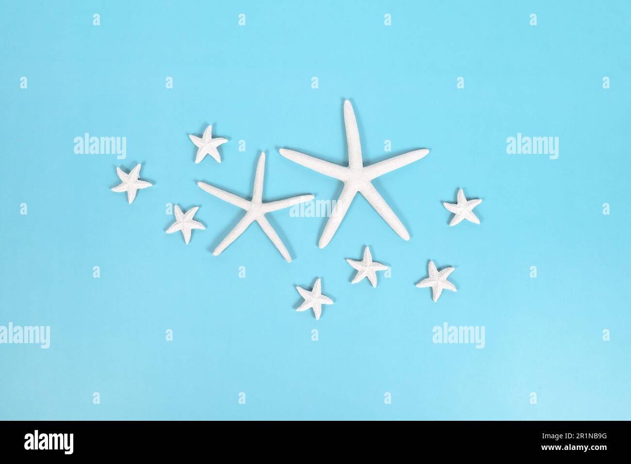 Different sized starfish on blue background Stock Photo - Alamy