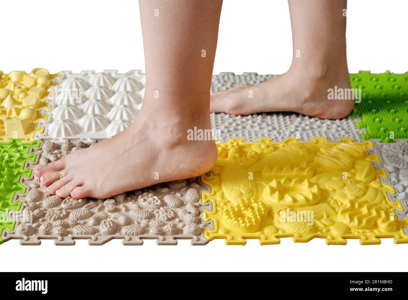Woman foots close-up on a medical orthopedic mat, isolated on white ...