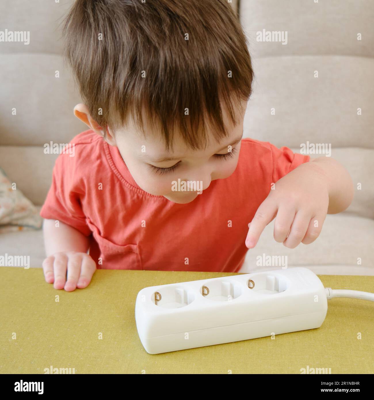 The baby's playtime with an electrical cord at home is a hazardous ...