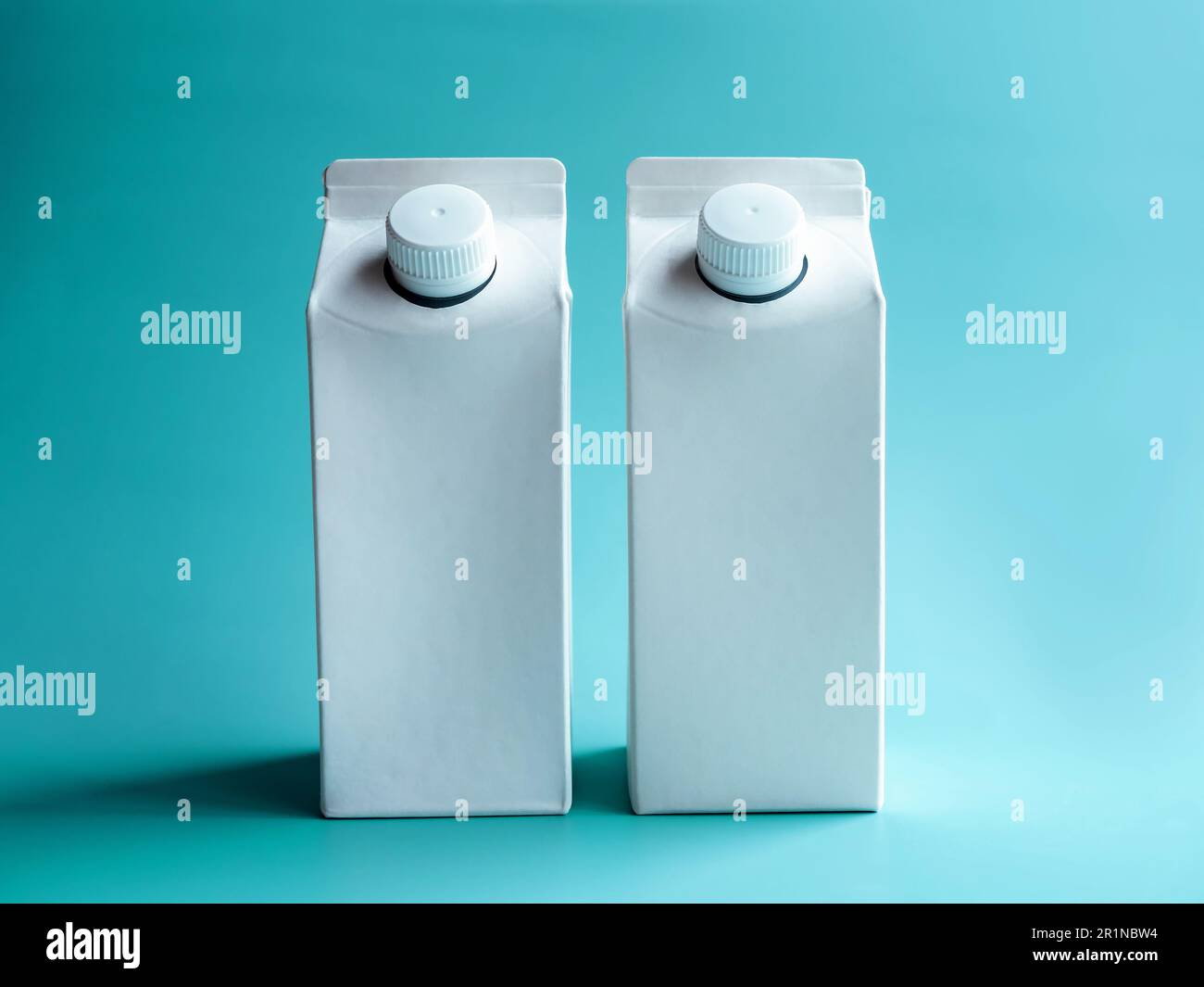 Mockup of two white milk or drinking water boxes 1 liter with screw cap ...