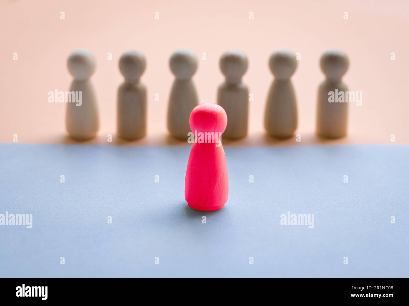 A red wooden doll facing a row of dolls separated by different floor ...