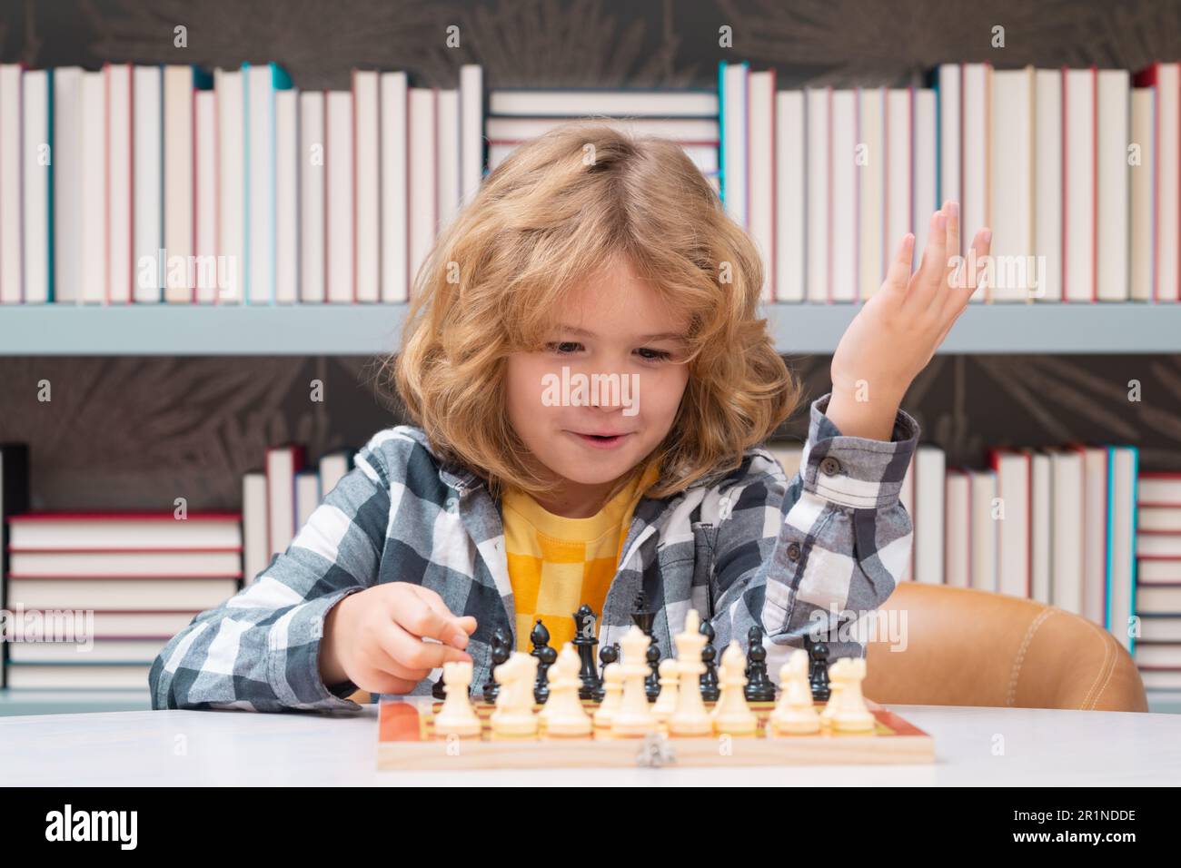 Kid play chess at school. Kid playing chess. Child thinking near ...