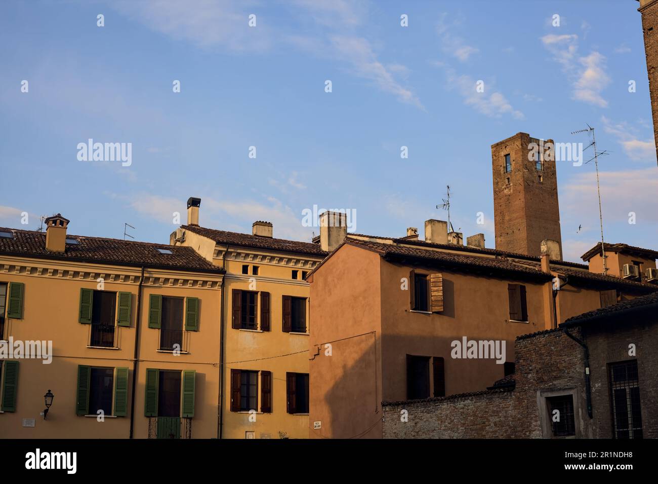 Buildings and a tower in the distance at sunset Stock Photo - Alamy
