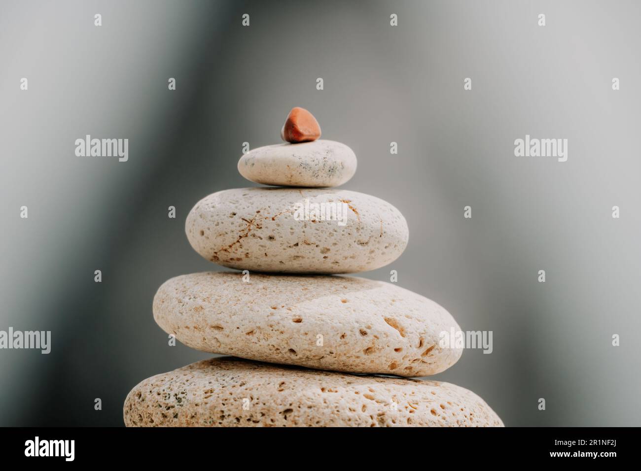 balanced rock pyramid stands tall on sea pebble beach. Selective focus ...
