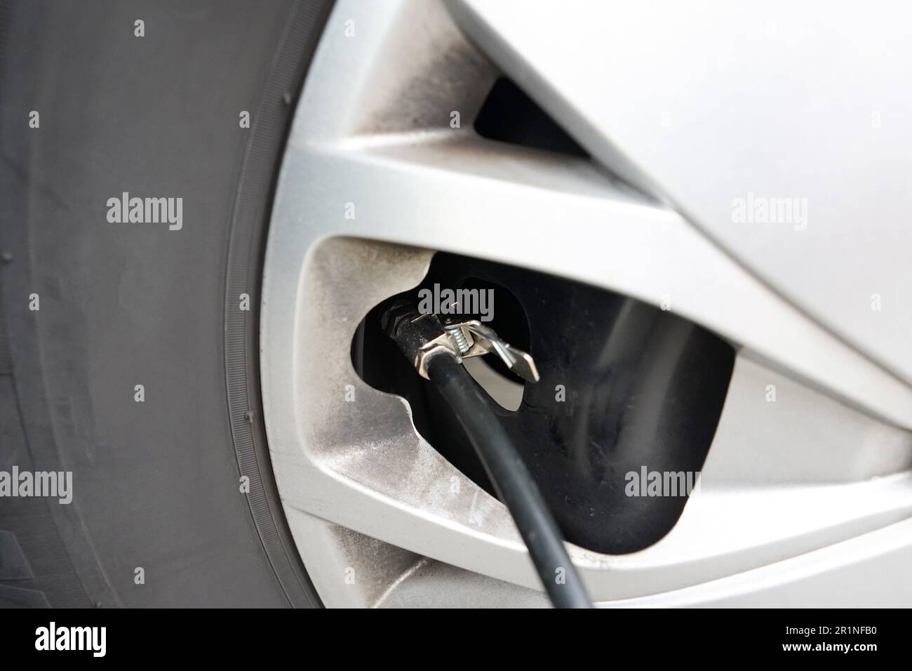 Pumping the tire at the station with the compressor. Checking pressure ...