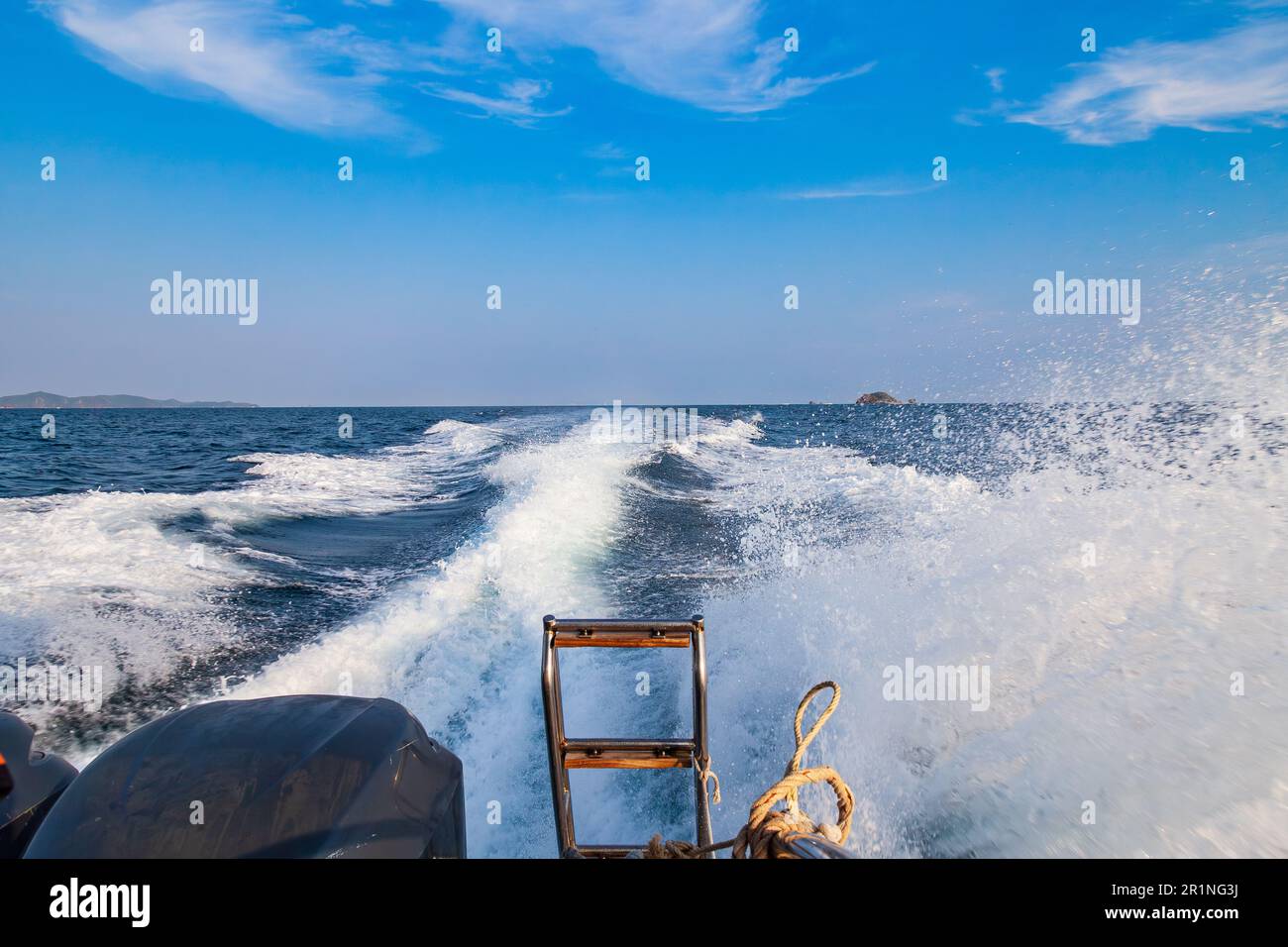 Waves from a speedboat on the blue sea with splashes and a trail from a ...