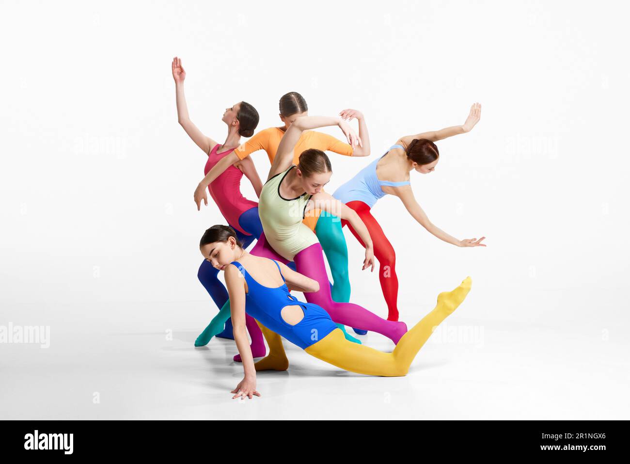 Group of artistic, young girls, ballerinas in multicolored clothes making performance, dancing ...