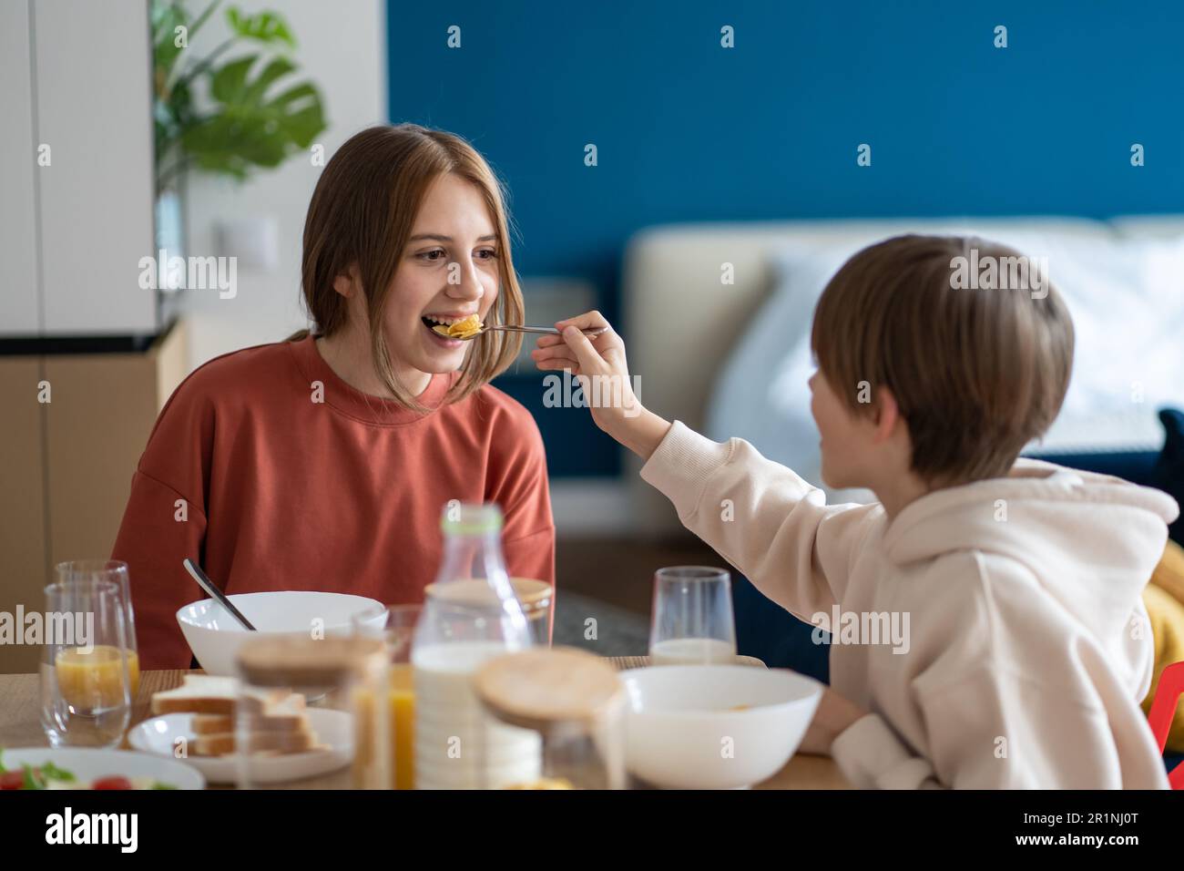 Happy kids siblings having fun together eating cereals in morning ...