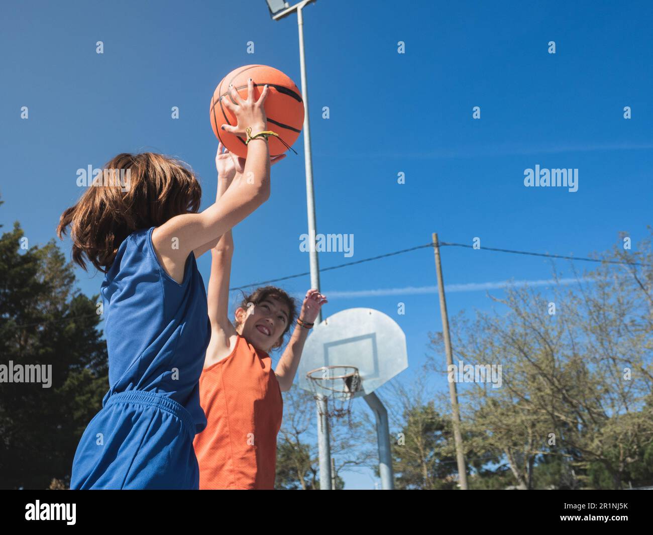 One-on-one basket shot between two boys on an outdoor court Stock Photo ...