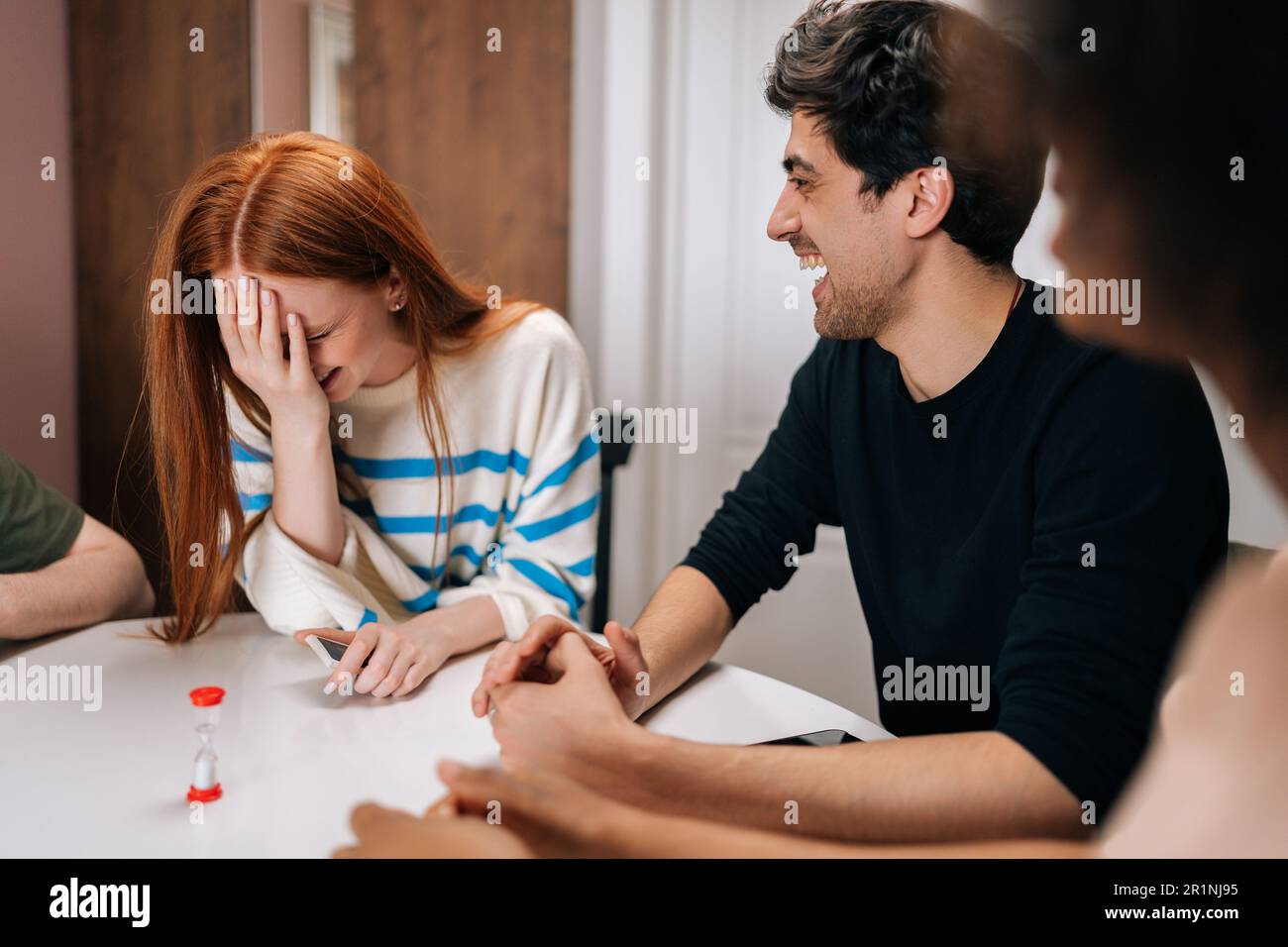 Happy laughing multiethnic friends having play cards games for time ...