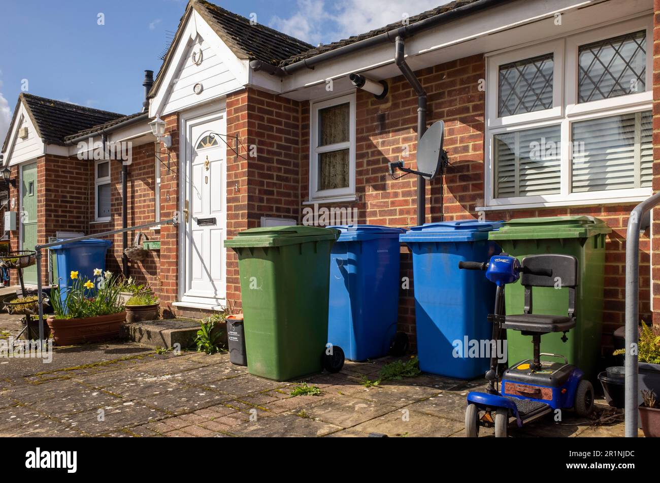 Green and blue recycling bins and mobility scooter outside a bungalow ...