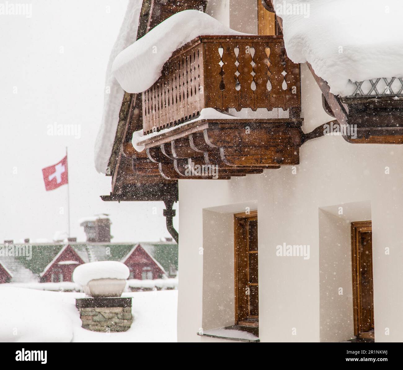 Swiss chalet during heavy snow with Swiss flag in background Stock ...
