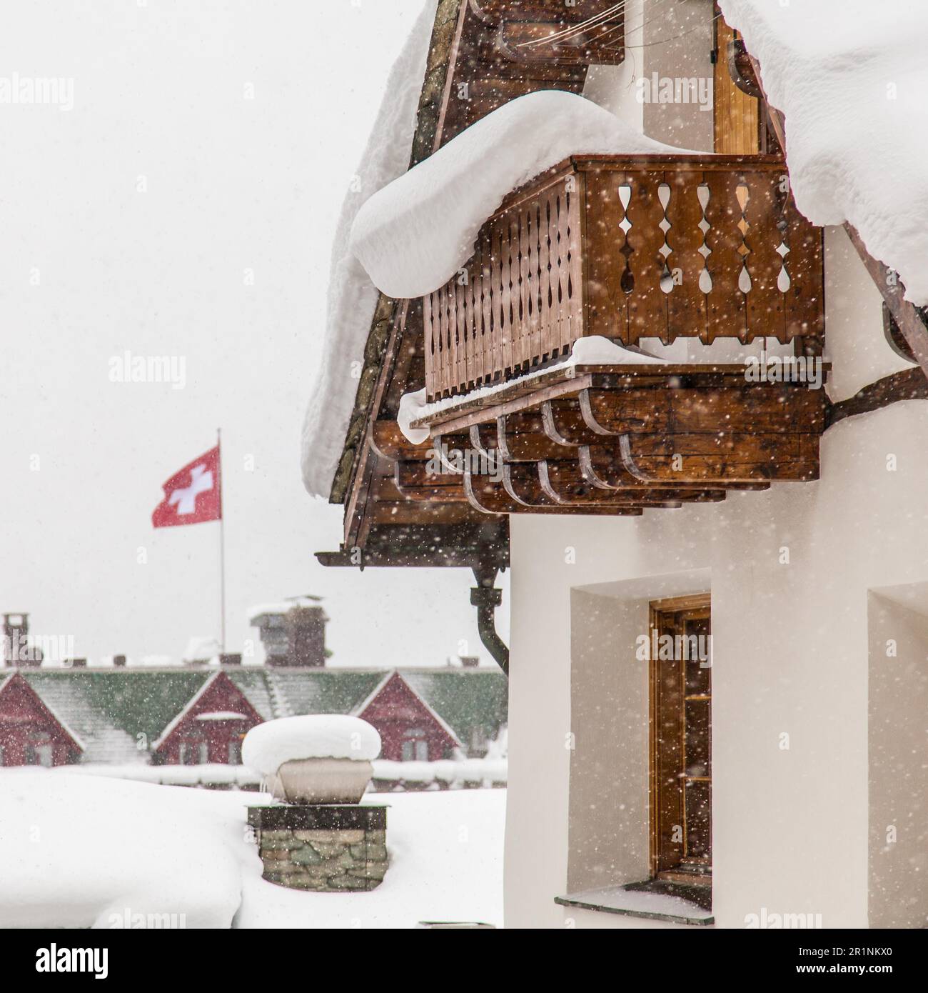 Swiss chalet during heavy snow with Swiss flag in background Stock ...