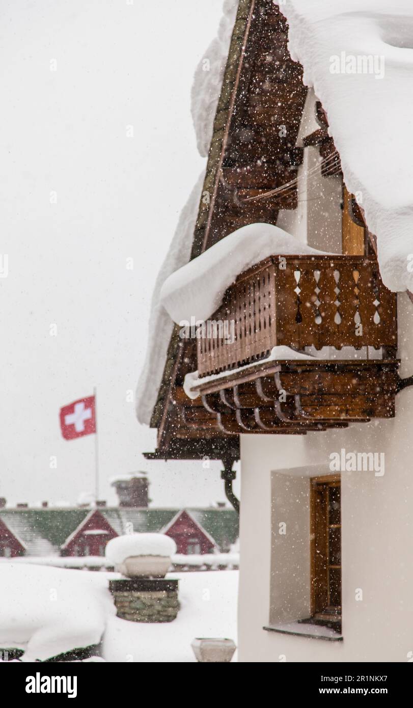 Swiss chalet during heavy snow with Swiss flag in background Stock ...
