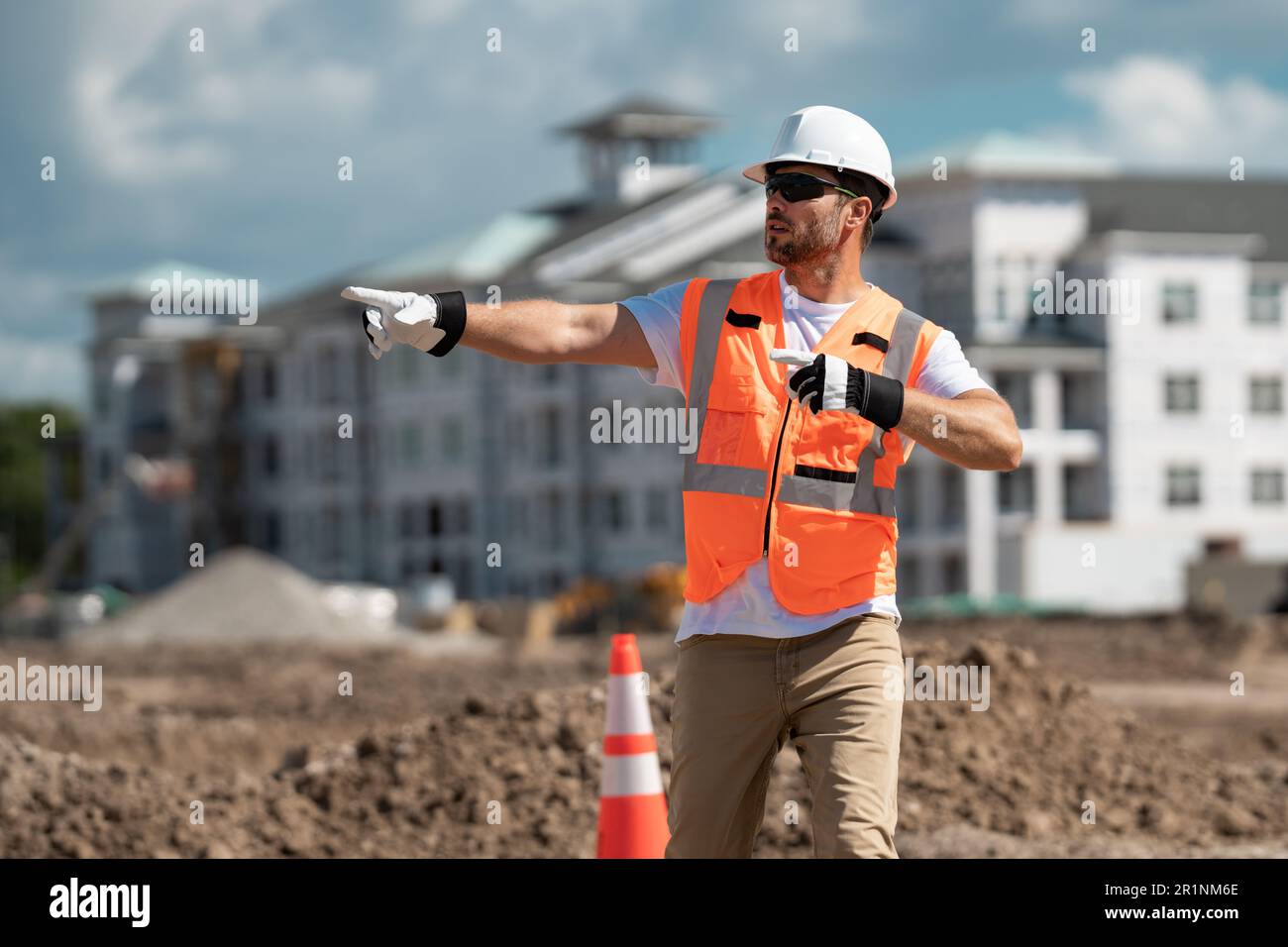 Construction site worker in helmet working outdoor. A builder in a ...