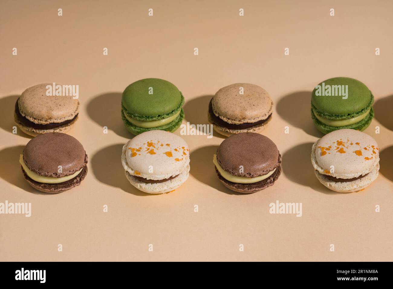 set of macaroons on beige background with a harsh light Stock Photo - Alamy
