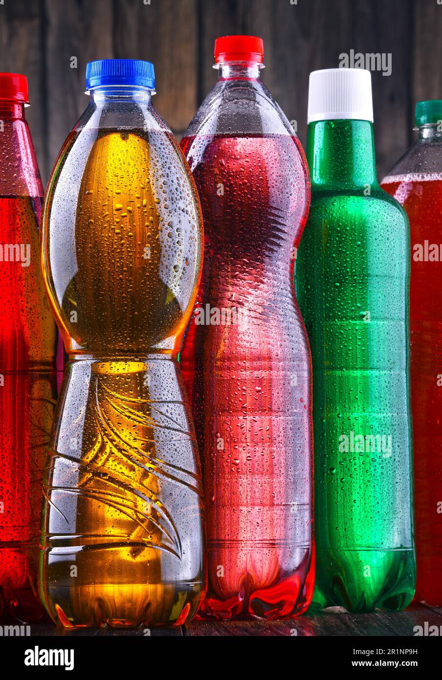 Plastic bottles of assorted carbonated soft drinks in variety of colors ...