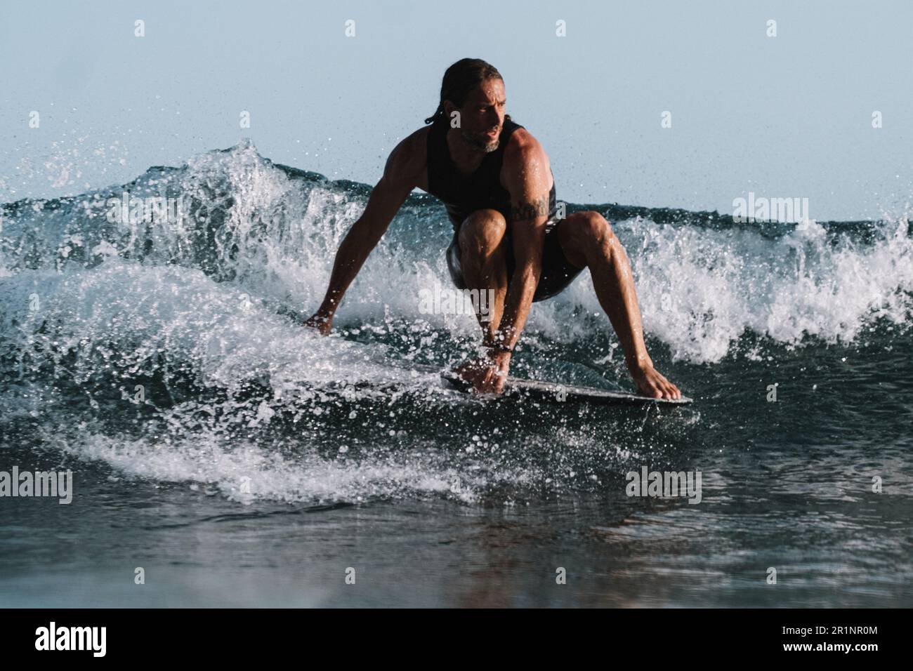 Full body of male surfer in sea at sunset Stock Photo - Alamy