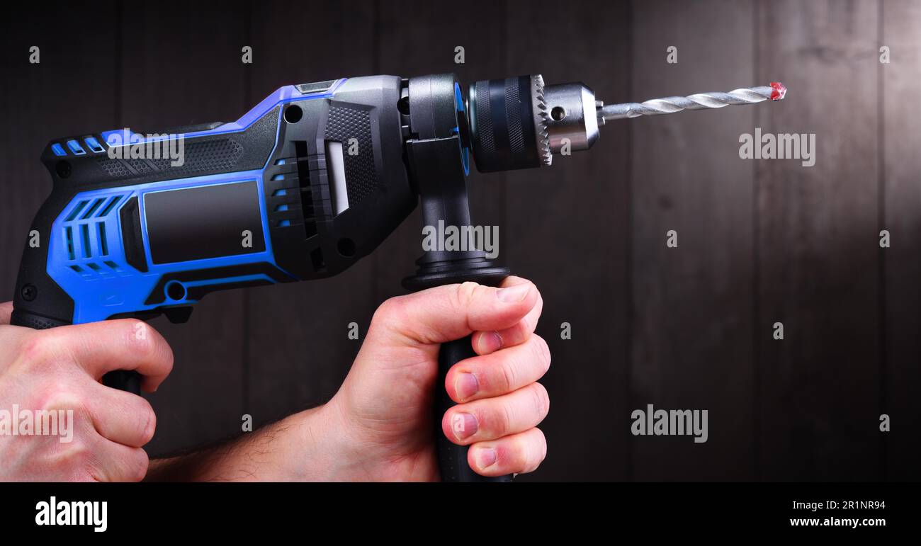 Male hands holding power drill Stock Photo - Alamy