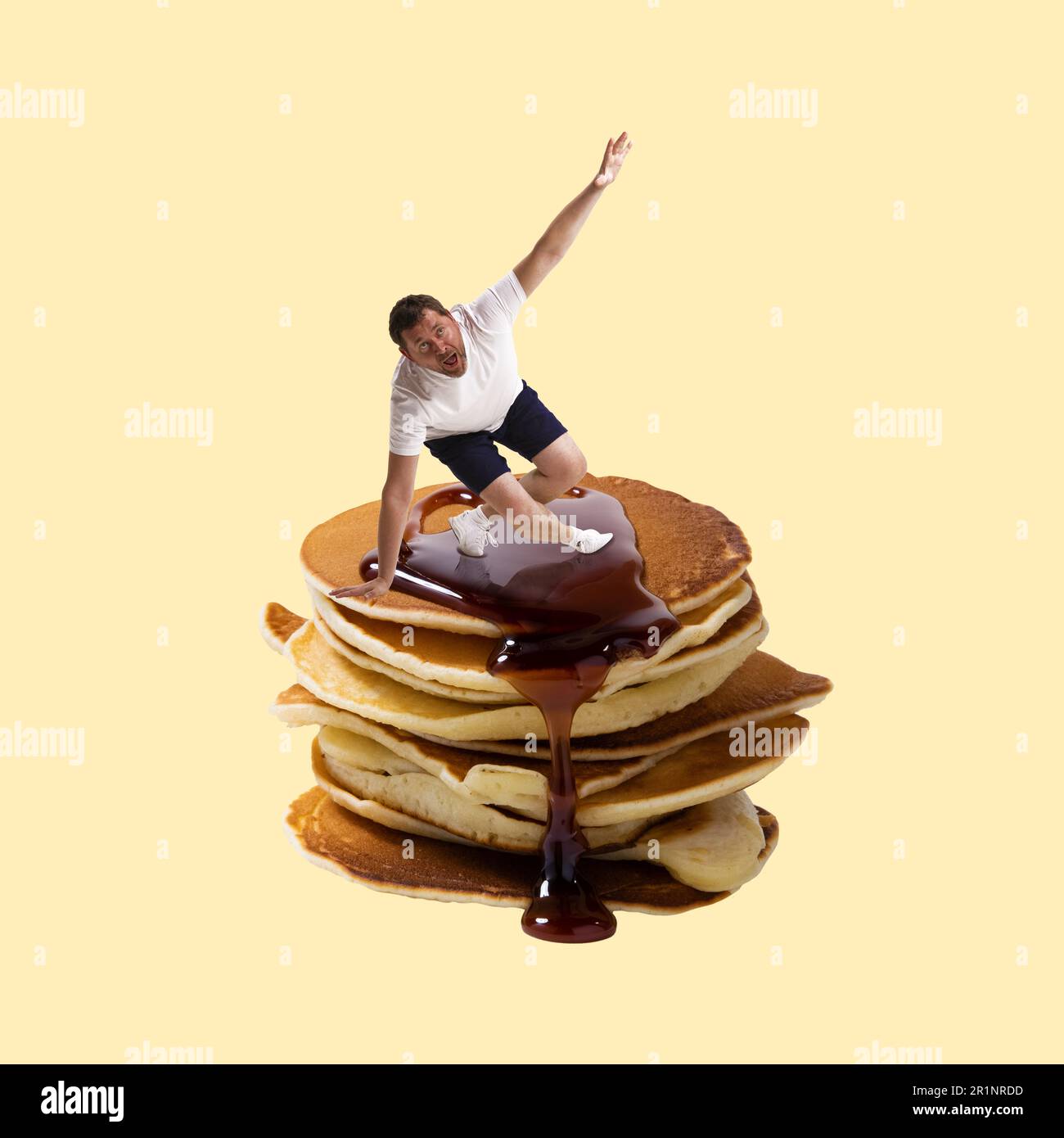 Man sliding on delicious pancakes with jam over yellow background ...