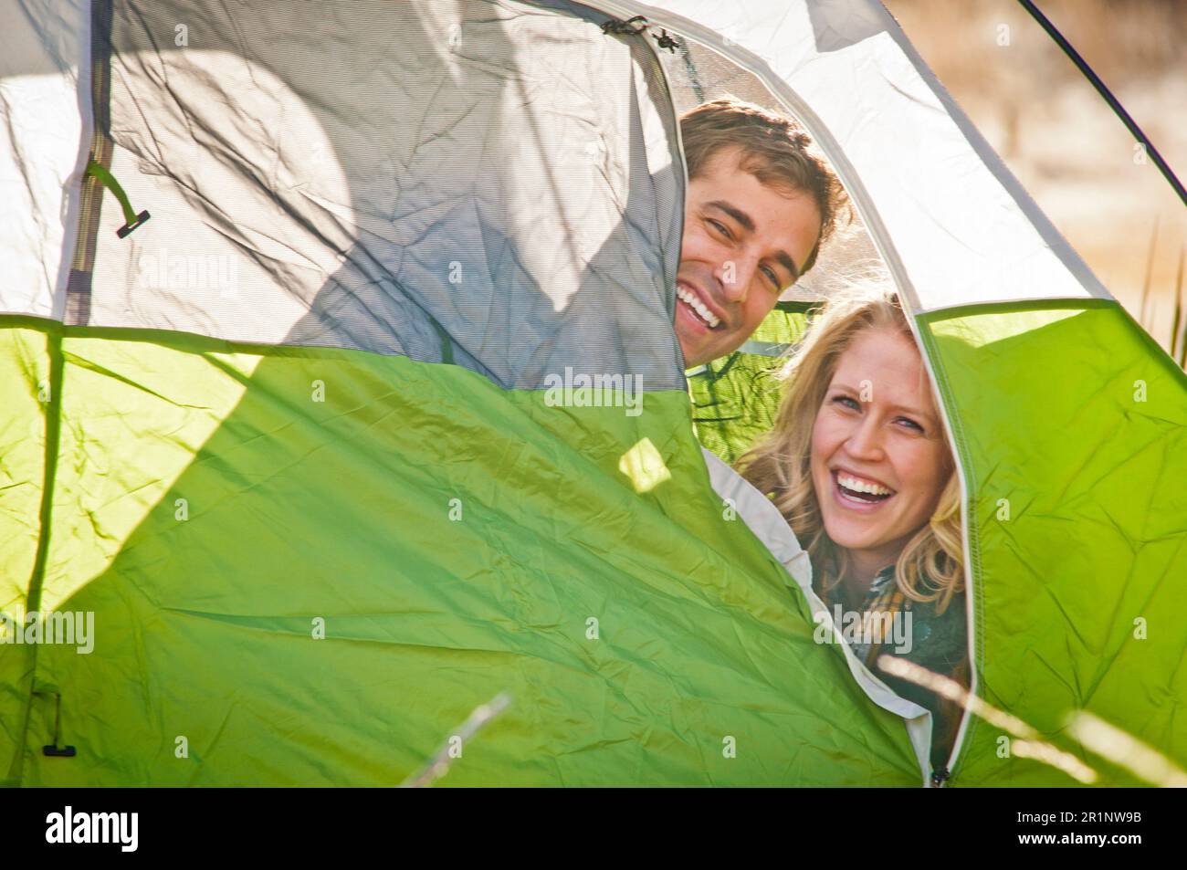 A couple peeking out of their tent Stock Photo - Alamy
