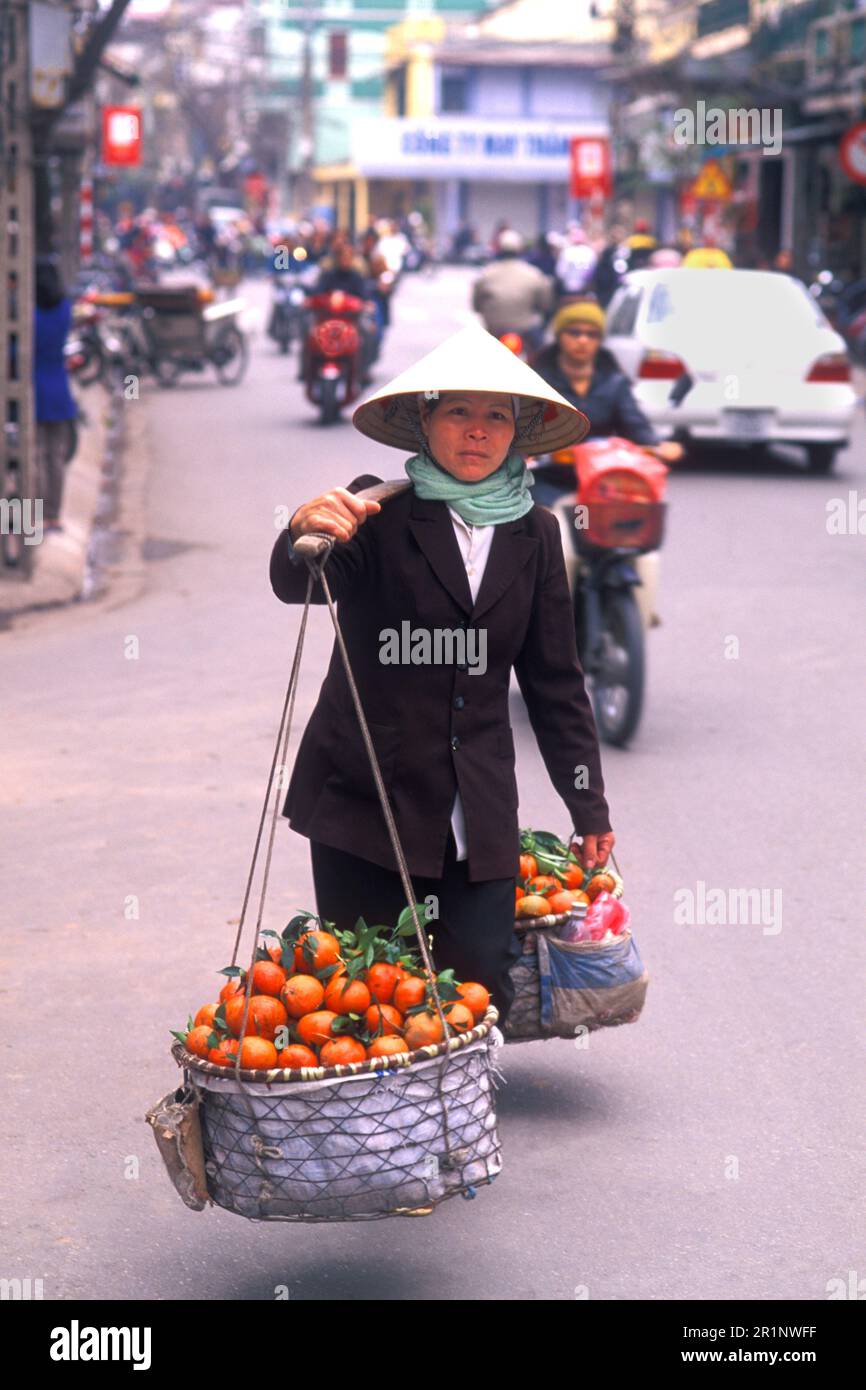 Traditional Woman Vendor in Straw Hat Carrying Oranges Over Shoulder ...