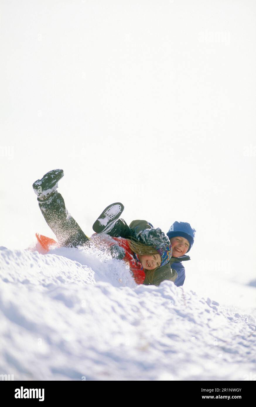 A boy and girl laugh while sledding in Montana Stock Photo - Alamy