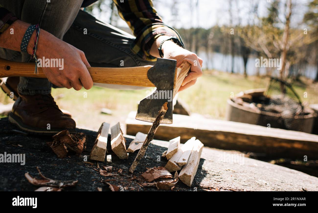 Man using an Axe to chop wood for a camp fire in the forest Stock Photo ...