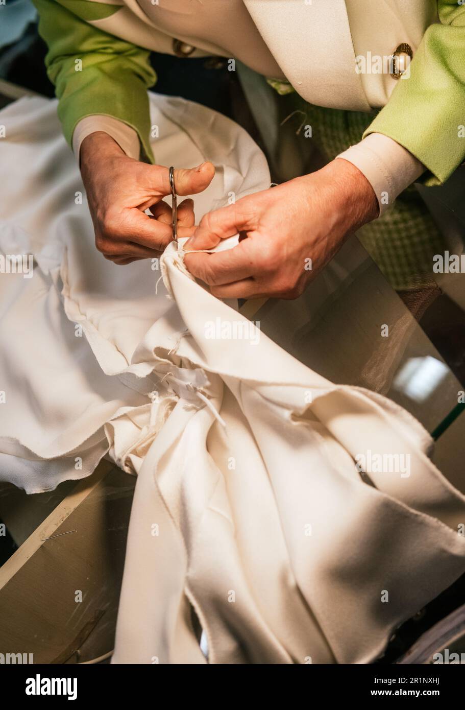 dressmaker cutting with scissors in her sewing workshop Stock Photo - Alamy