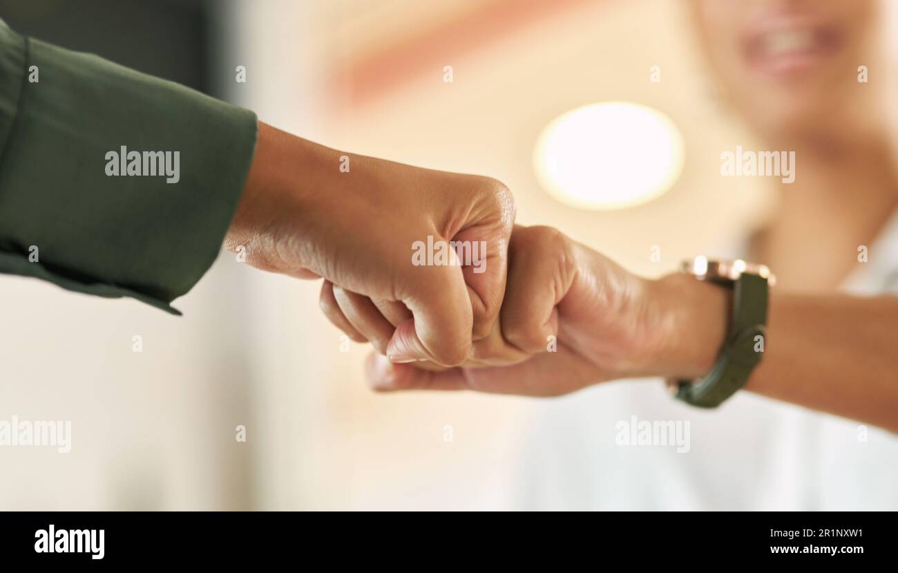 Greeting each other in a safe way. two businesswomen fist bumping each ...