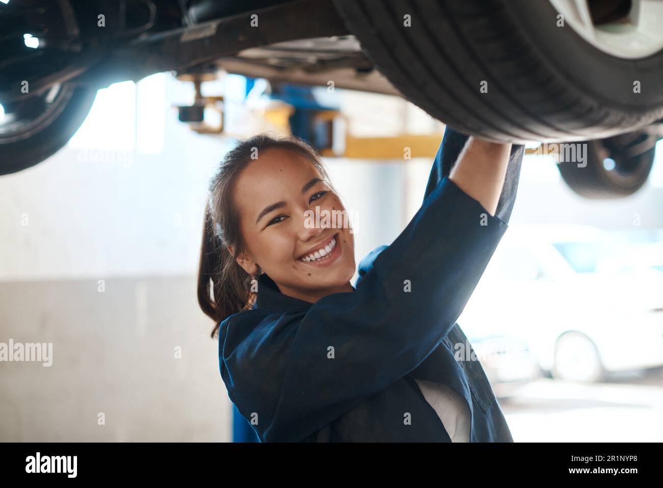 Theres always a car that needs fixing. a female mechanic working under ...
